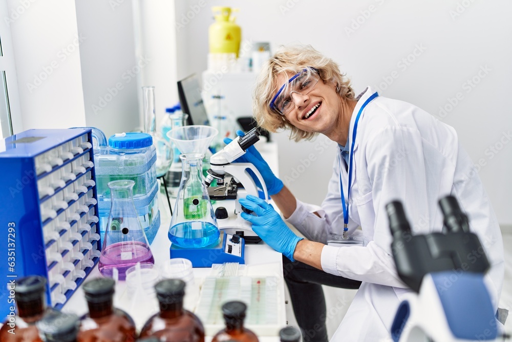 Young blond man scientist using microscope at laboratory Stock Photo ...