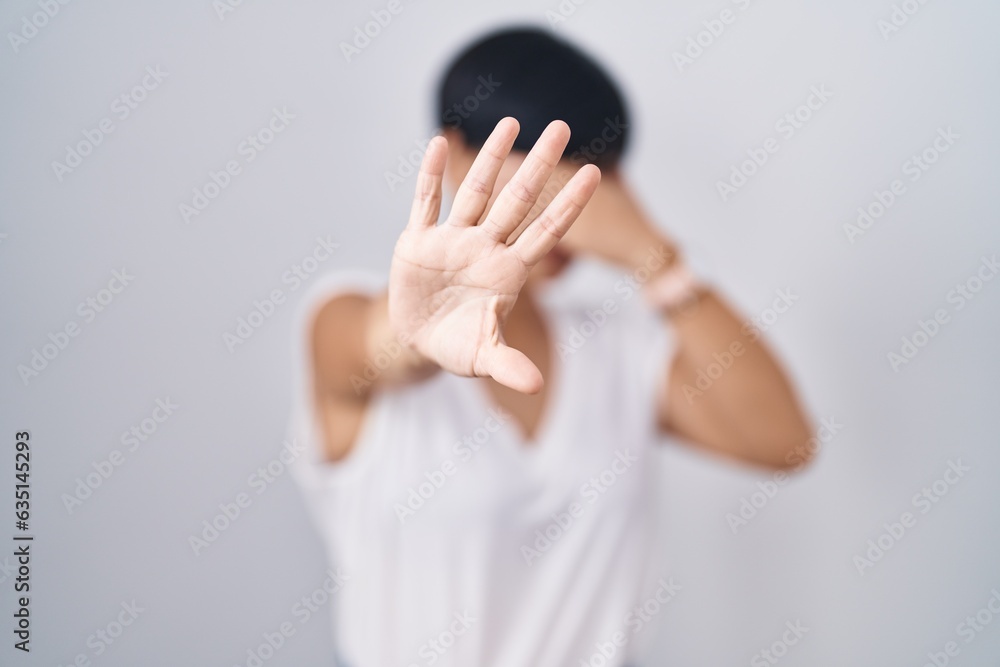 Young asian woman with short hair standing over isolated background ...