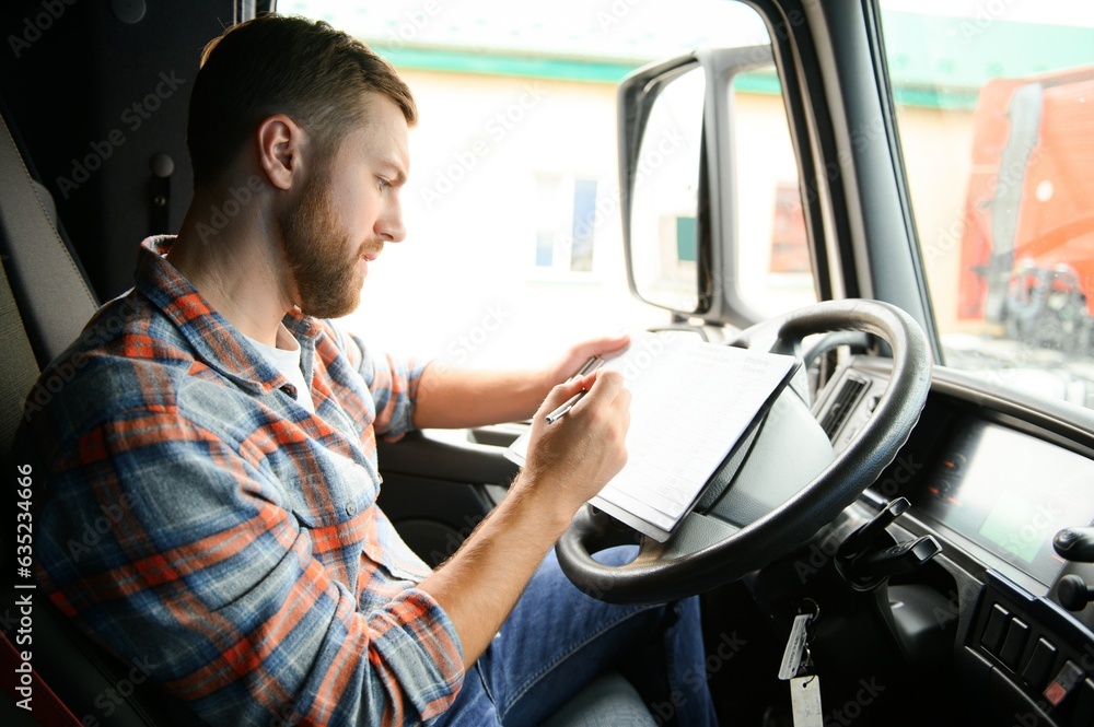 forwarder driver sits behind the wheel of a car and examines waybills ...