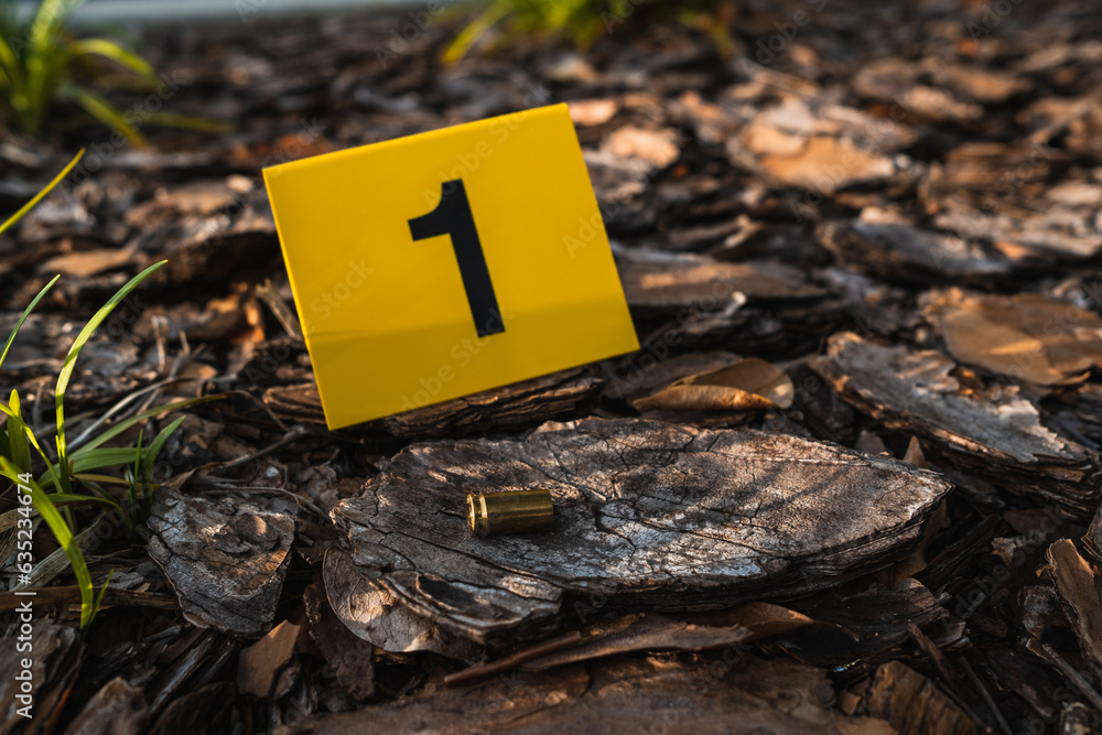 One yellow crime scene evidence marker on the ground after a gun ...