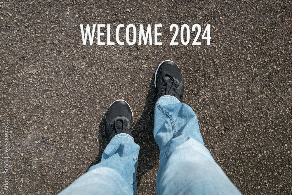 Welcome 2024, word on street in front of woman. Top view. Stock Photo ...
