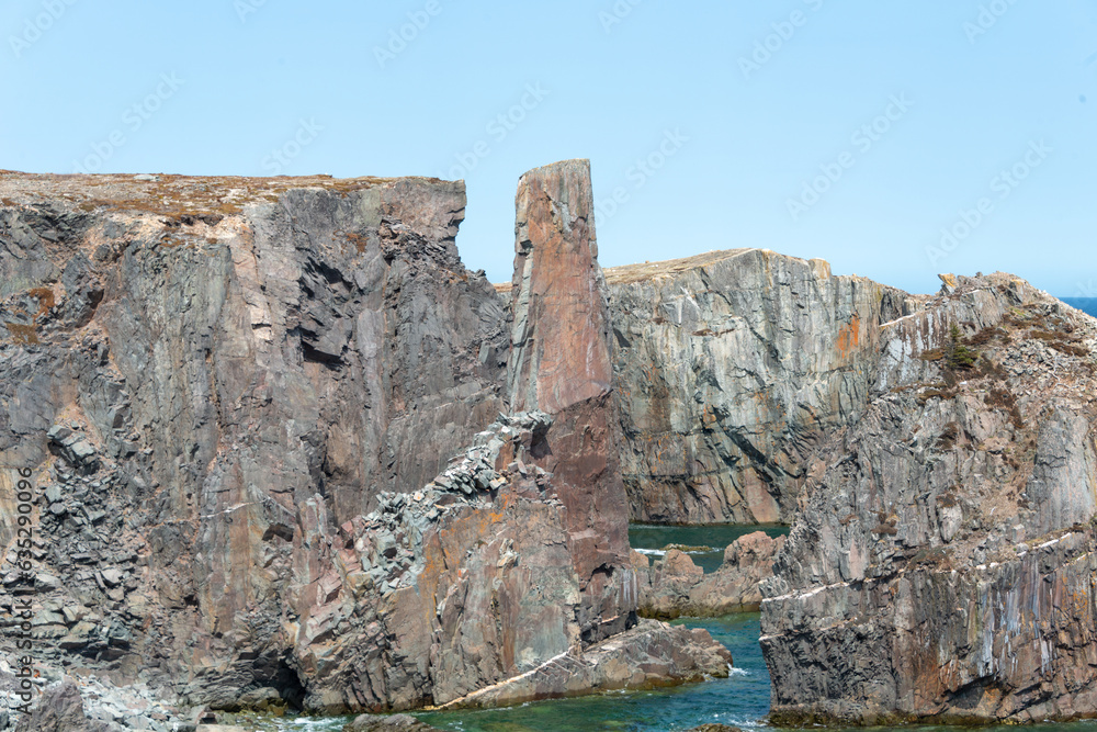 Multiple sea stacks and a rugged rocky coastline. The textured pillar ...