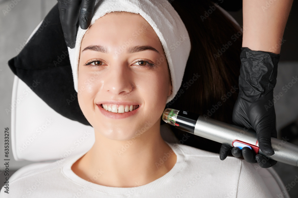 Top view of medical esthetician using radiofrequency device while ...