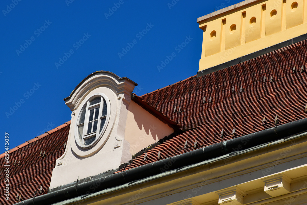 sloped red clay residential roof with decorative yellow stucco chimney ...