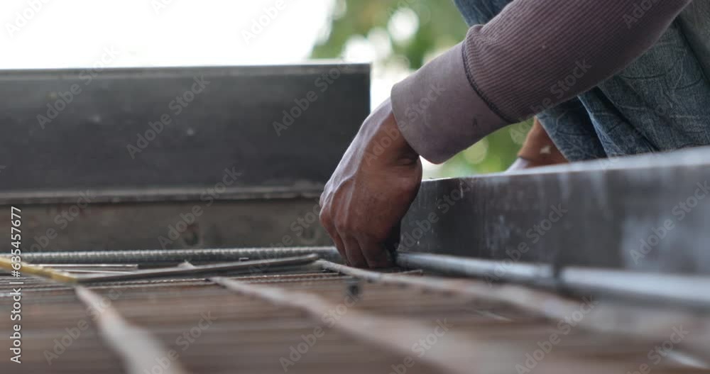 Reinforced concrete structures. Construction worker uses pilers tools ...