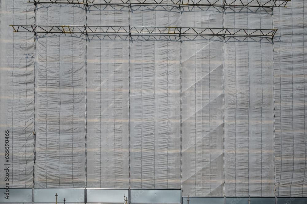 Front exterior view of net wrap scaffolding in front of building at ...