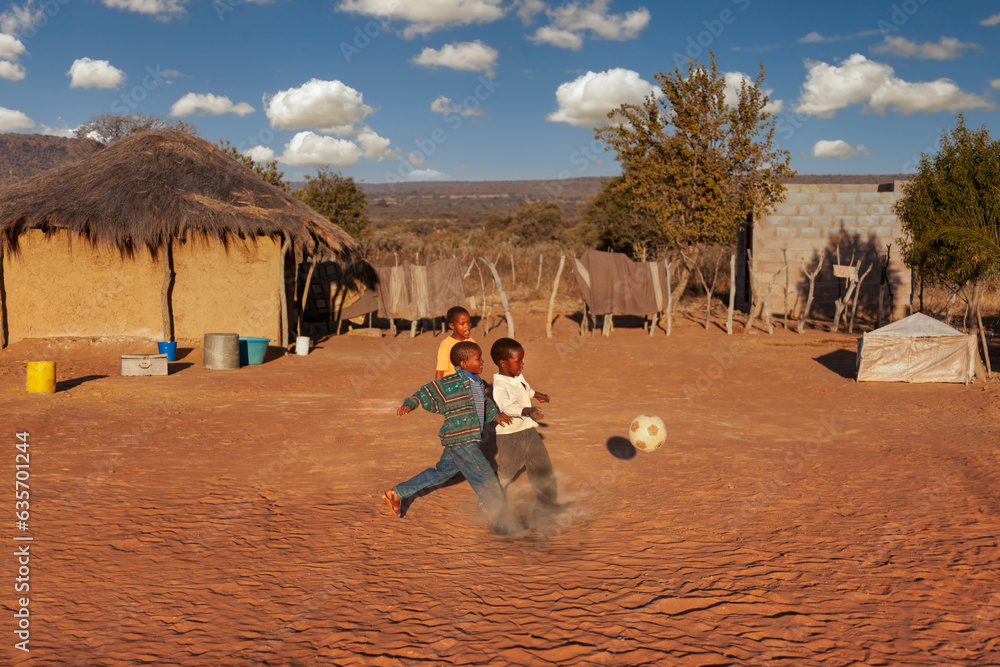 village african kids playing soccer on an improvised football field in ...