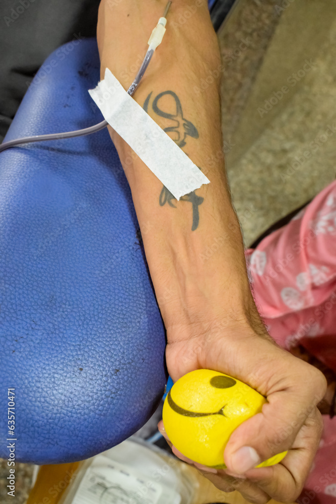 Blood donor at Blood donation camp held with a bouncy ball holding in ...