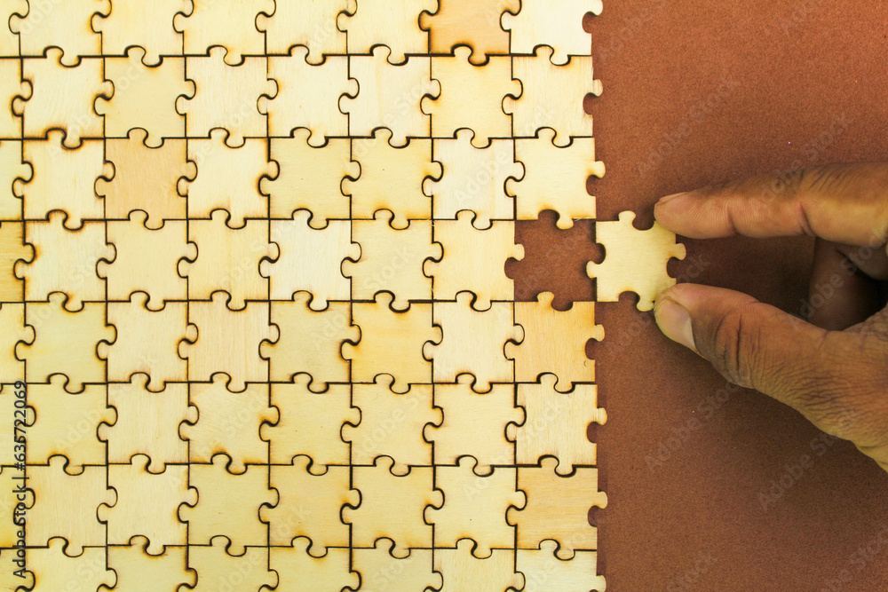 hand holding the last puzzle to be solved or finished. Compliting final ... hand holding the last puzzle to be solved or finished. Compliting final ...
