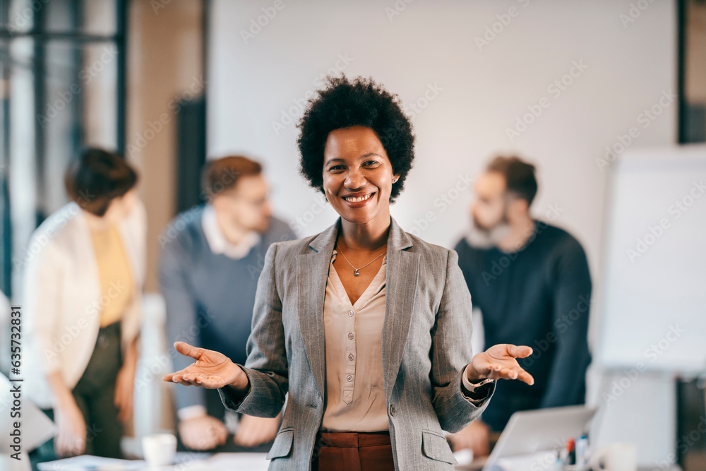 A businesswoman is standing at the office and welcoming people while ...