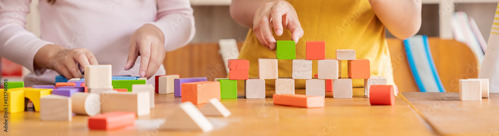 close up hands of little children playing blocks in classroom. Learning ...