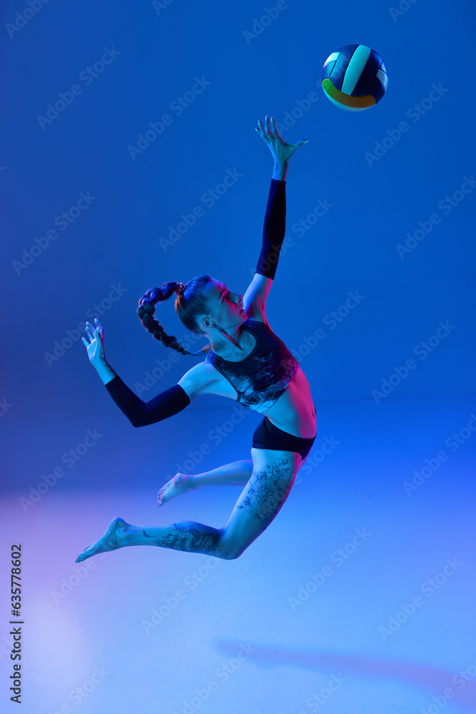 Competitive girl, volleyball player hitting ball with strength against ...