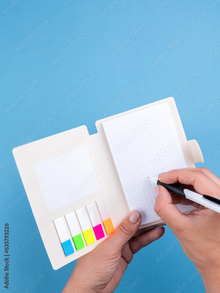 Design concept - top view of a woman writing in a notebook with white ...