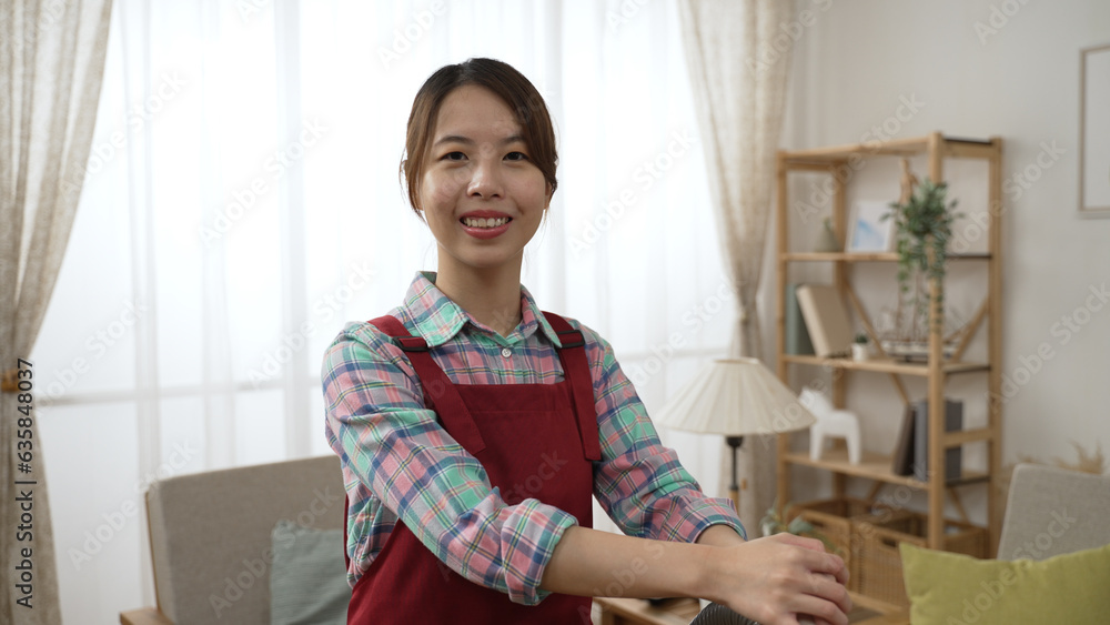 slow motion of young asian wife in apron using vacuum cleaning by sofa ...
