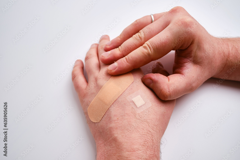 Male hand with a medical adhesive plaster close-up. Adhesive plaster on ...