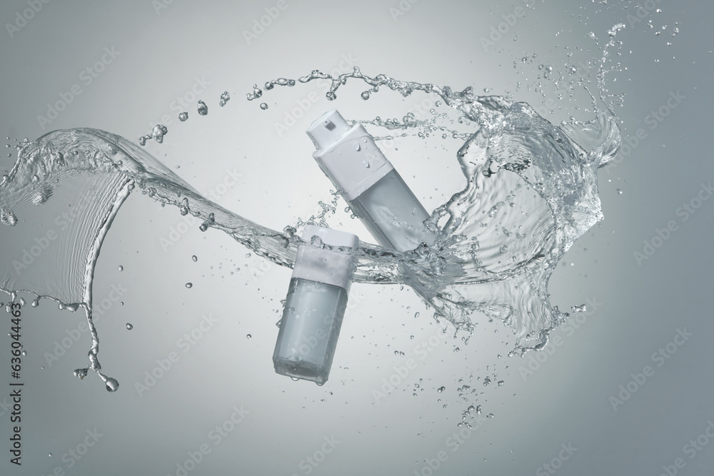 Bottles of cream with splash water isolated on gray background Stock ...
