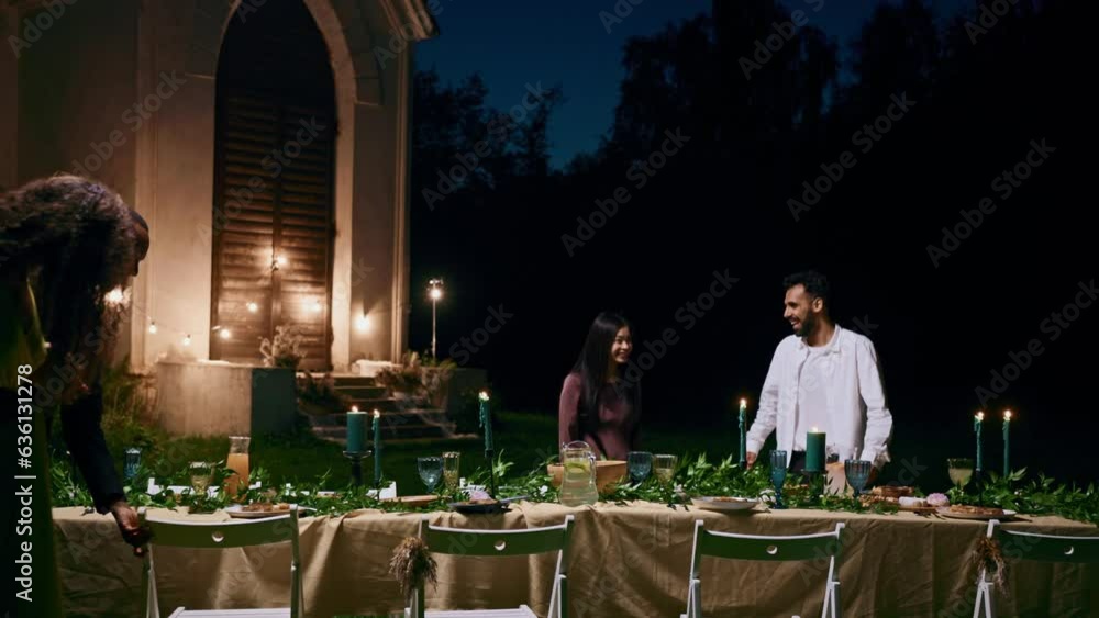 The guests sit down at the festive table at the outdoor wedding, the ...