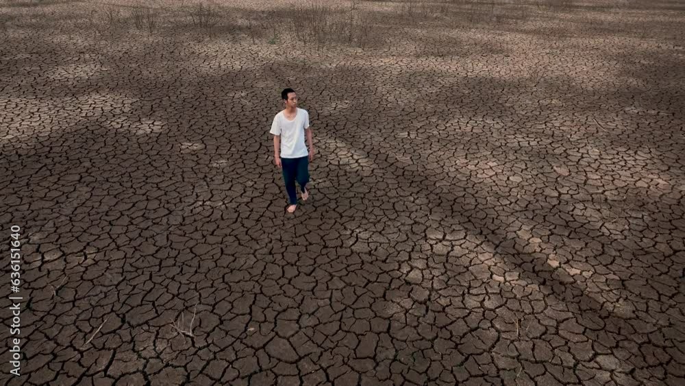 Landscape of Sad young man walking on cracked earth at dry river ...