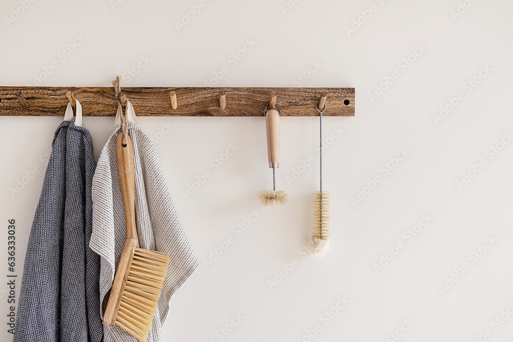Wood hook rack with tea towels, broom and dish bottle brush hanging on ...