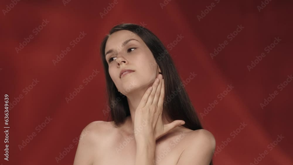 The woman touches the skin of the face, neck and shoulders, enjoys the ...
