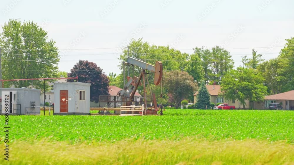 Oil pump jacks near farming field or farm. Oil industry and crude oil ...