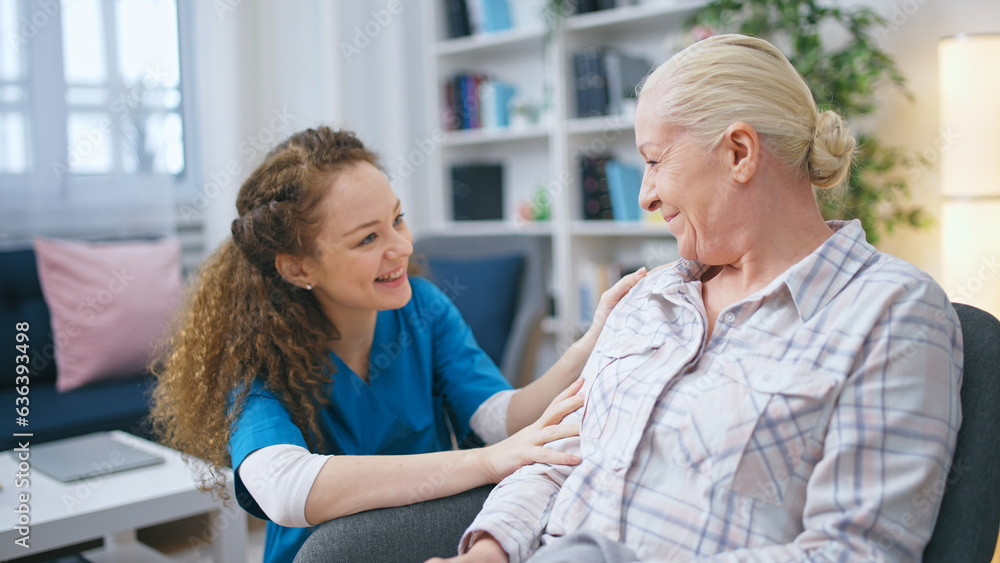 A smiling female social worker visits a senior lady at her home to ...