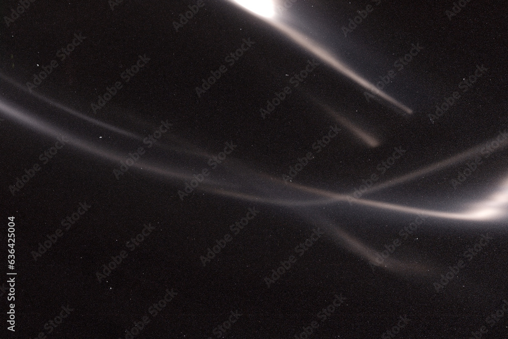 Abstract light streaks flares glowing in dark with vintage film grain ...