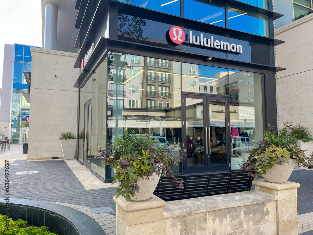 Close-up large Lululemon logo at façade entrance of store front glass ...