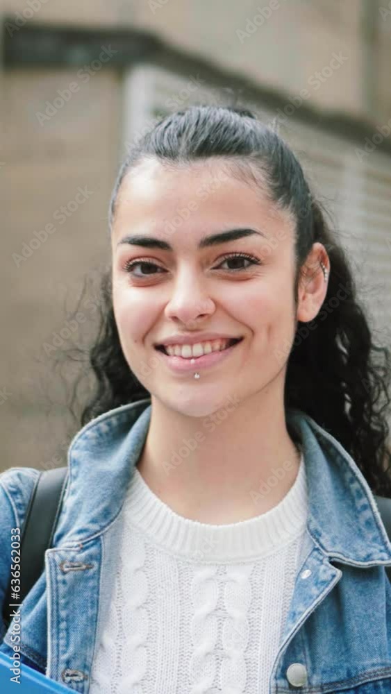 Vertical portrait of a pretty hispanic female student smiling and ...