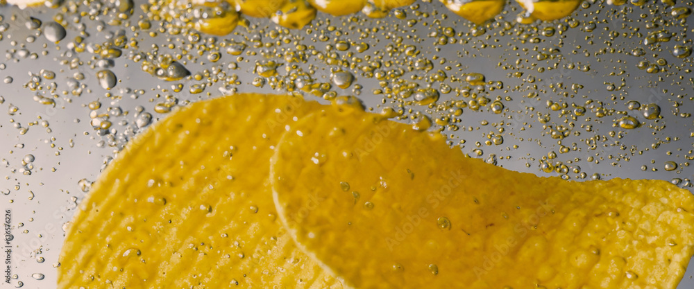 Deep fried potato chips under golden oil water. Frying rounded potatoes ...