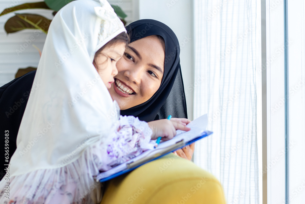 Muslim woman with Hijab teaching little girl with hijab. Traditional ...