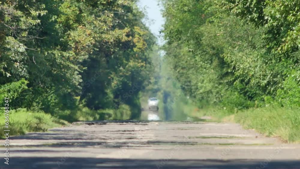 Heat waves with mirage over road on hot summer day. Car drives along ...
