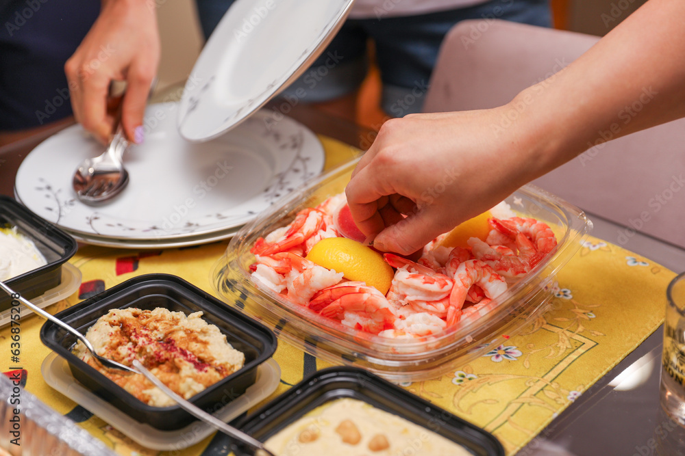 Hands and utensils gather around, embracing the communal spirit of a ...