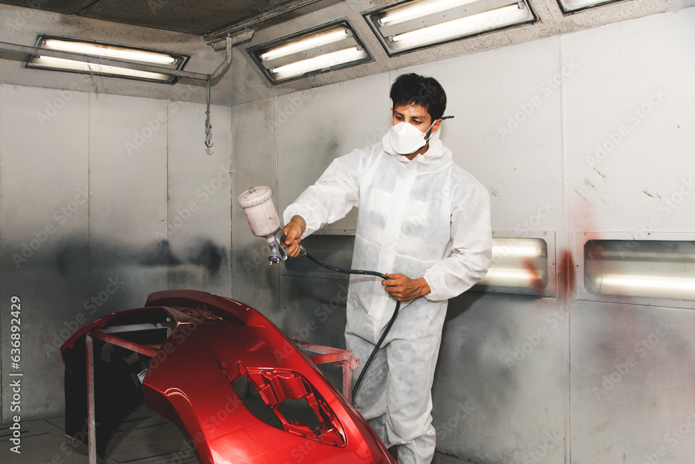 Automotive paint services : Male painter skilled using red spray paint ...