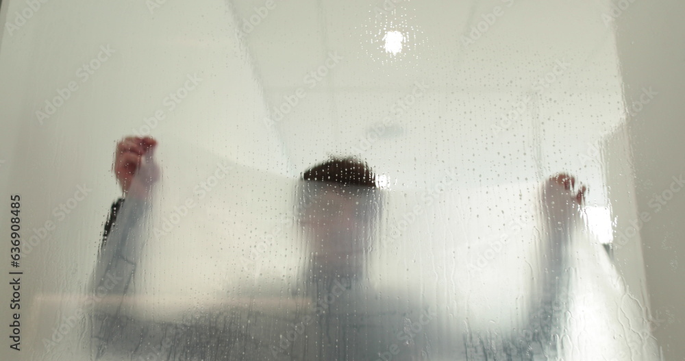 A man pastes a frosted coating on a glass door in a clinic to make the ...