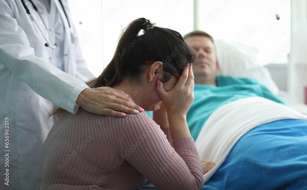 Woman in clinic crying near man in hospital bed. Unique care system for ...