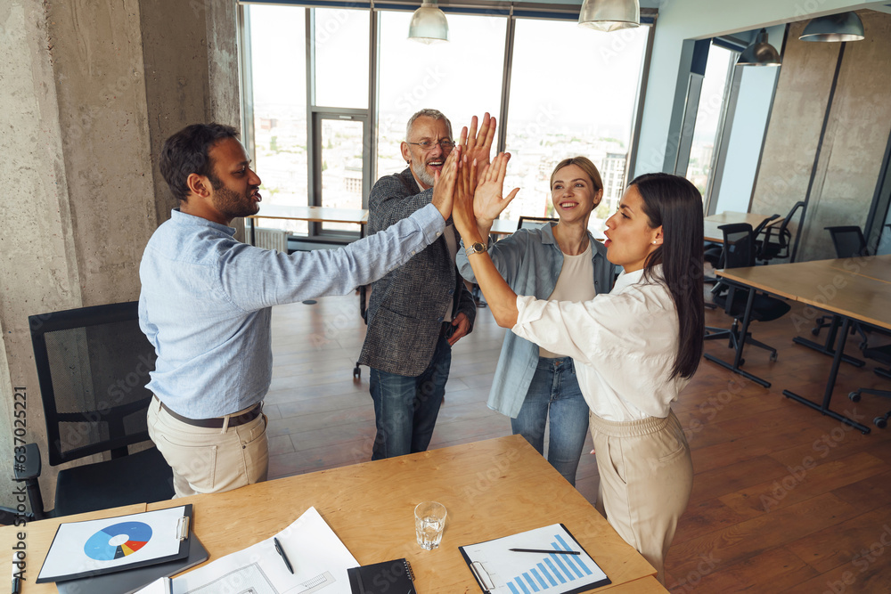 Group of happy colleagues stacked hands after finishing project in ...