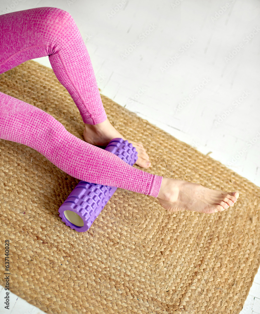 Woman's legs in pink sportswear lie down barefoot on a woven eco mat ...
