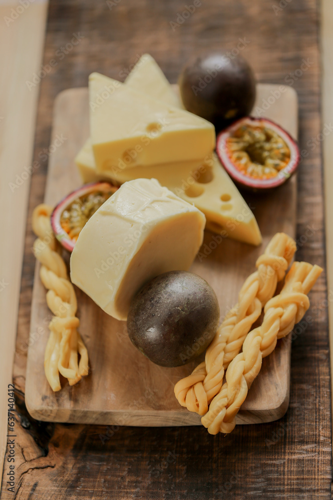 Cheese platter with fruitsassorted cheese on a wooden board with herbs ...