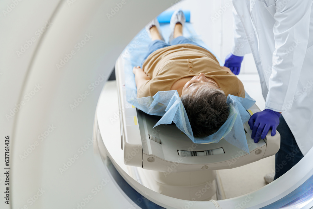 Radiologist controls MRI or CT Scan with patient undergoing procedure ...