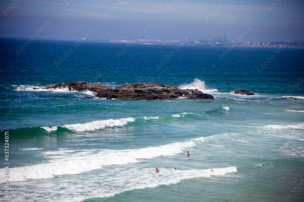 Vibrant scene at Porto Covo's expansive beach: bathers enjoying the ...