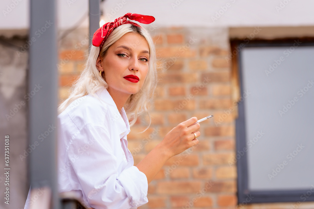 Blond haired woman with hair scharf and red lipstick smoking cigarette ...