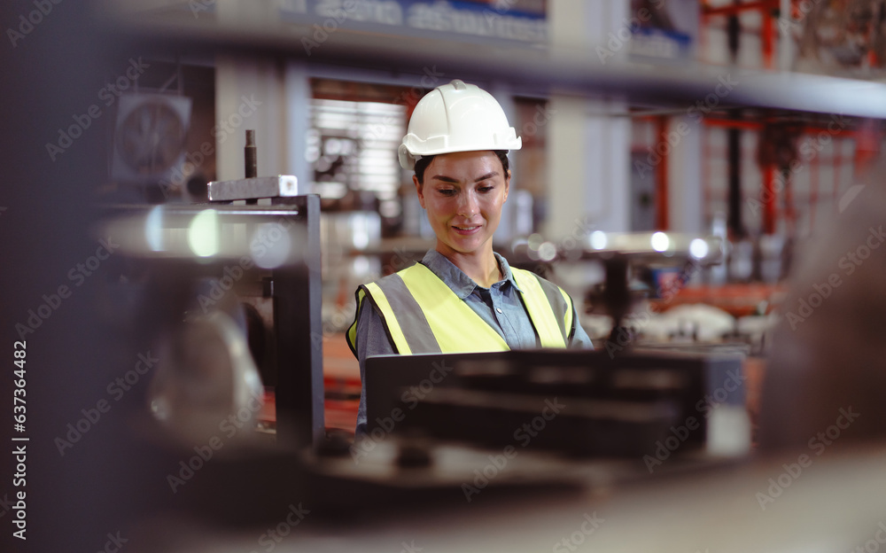 Confident industrial engineer woman in safety helmet working in heavy ...