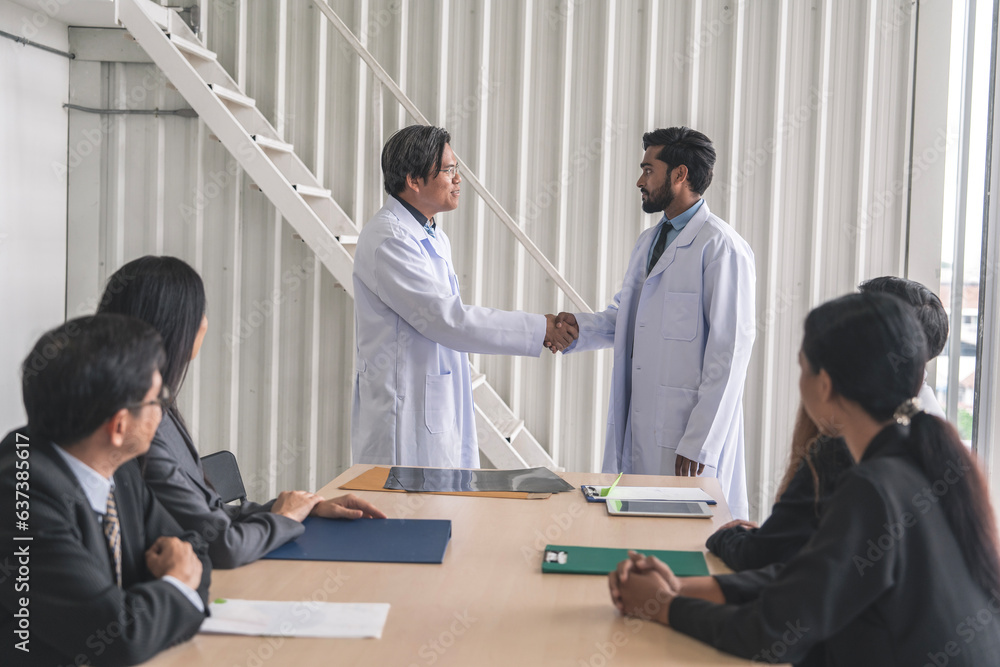 Indian doctors shaking hands with Asian male doctors congratulating ...