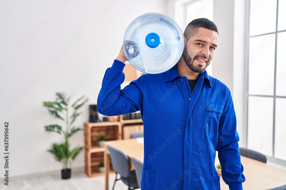 Hispanic service man holding a gallon bottle of water for delivery ...