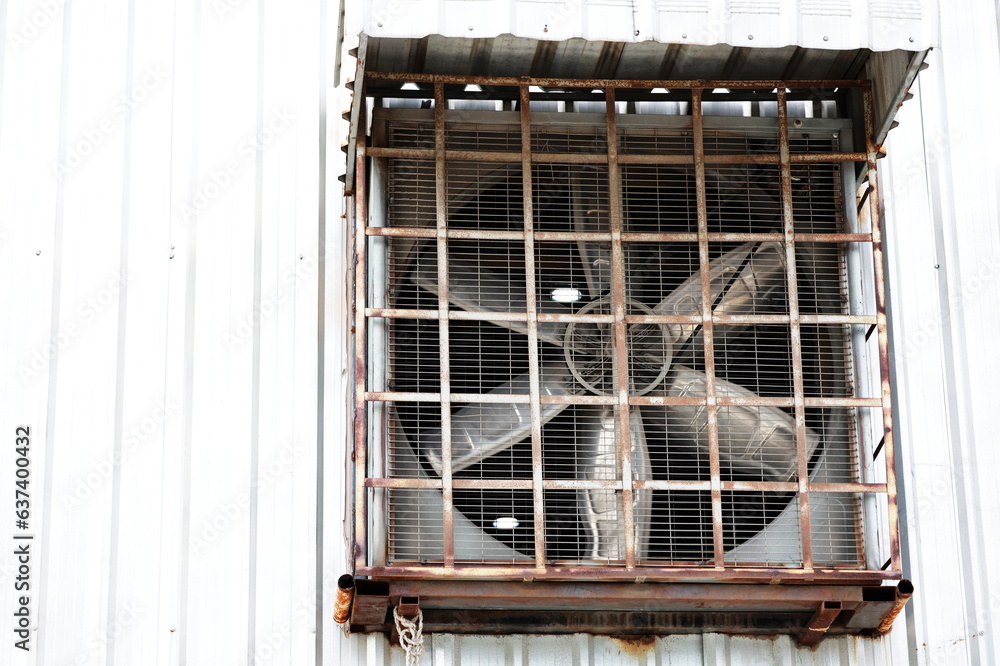 Industrial exhaust fans are installed outside the building with a roof ...