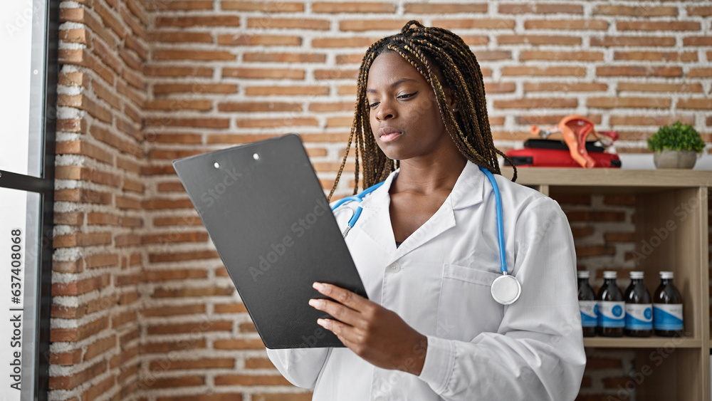 African american woman doctor writing medical report with serious face ...