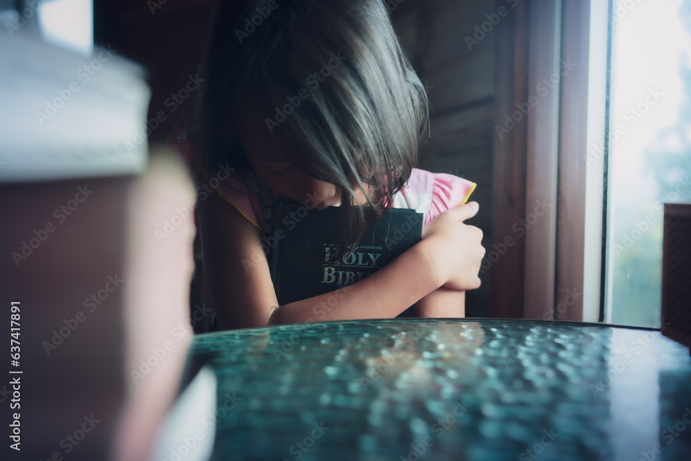 Child girl hugging the bible and praying with faith, christian concept ...