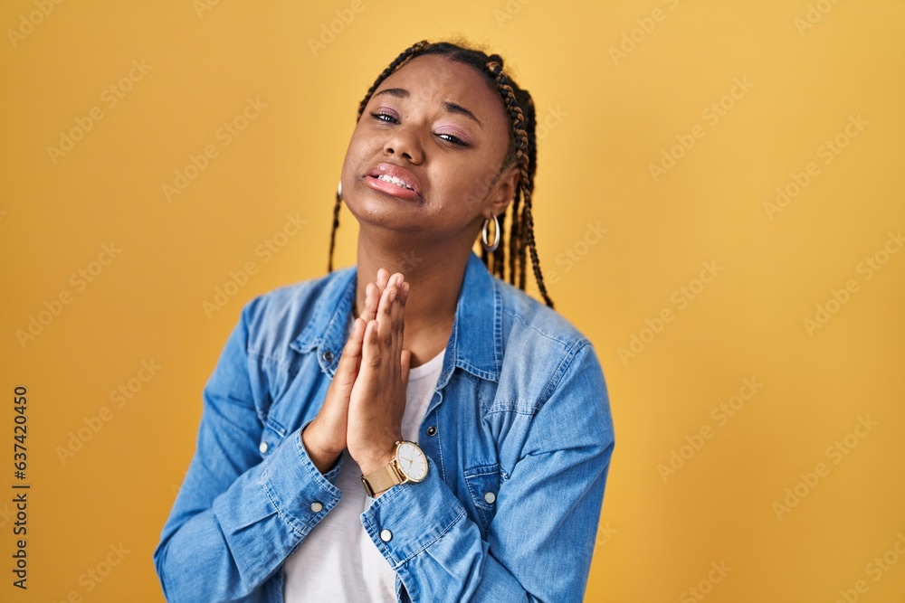 African american woman with braids standing over yellow background ...