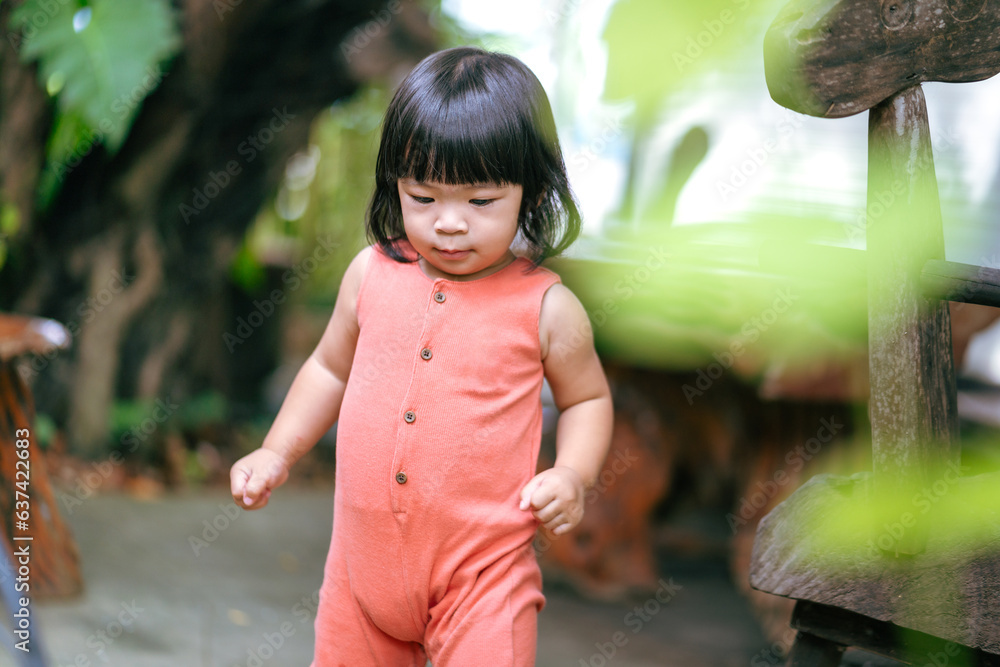 Portrait photo of white little girl with black hair is wearing orange ...